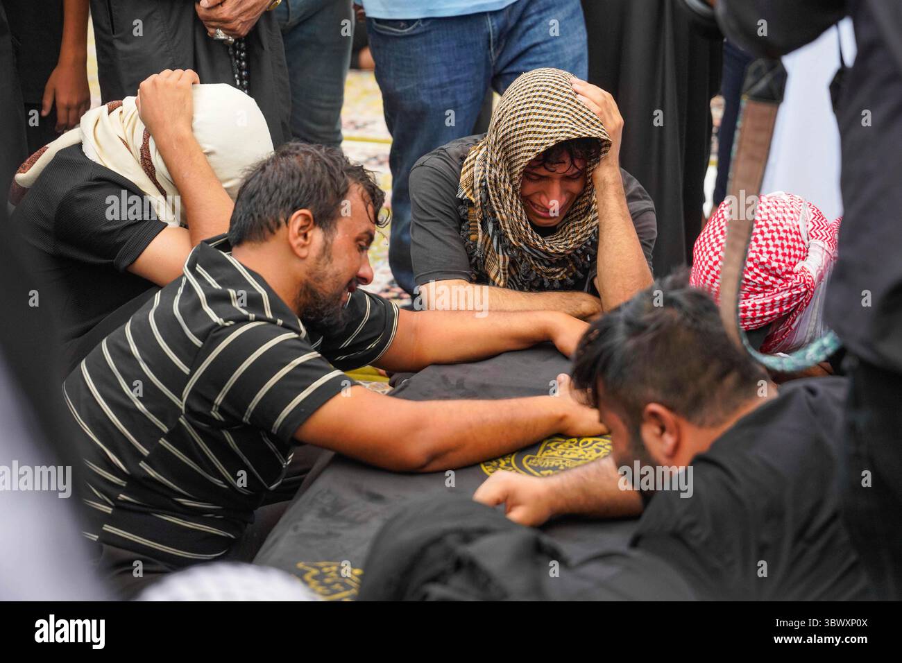 Mourners attend the funeral of victims who died in a fire at a shopping ...