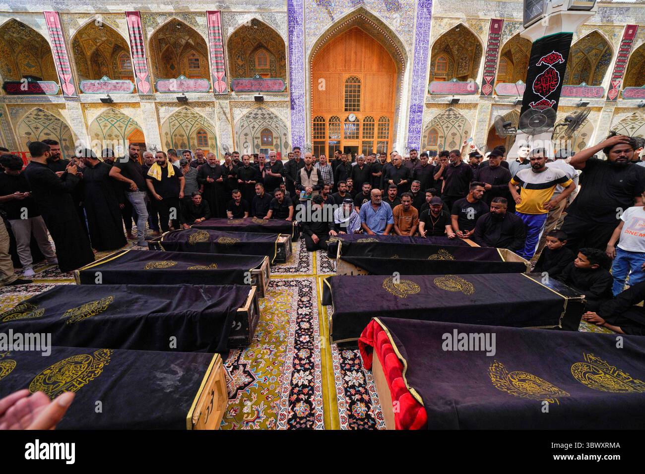 Mourners attend the funeral of victims who died in a fire at a shopping ...