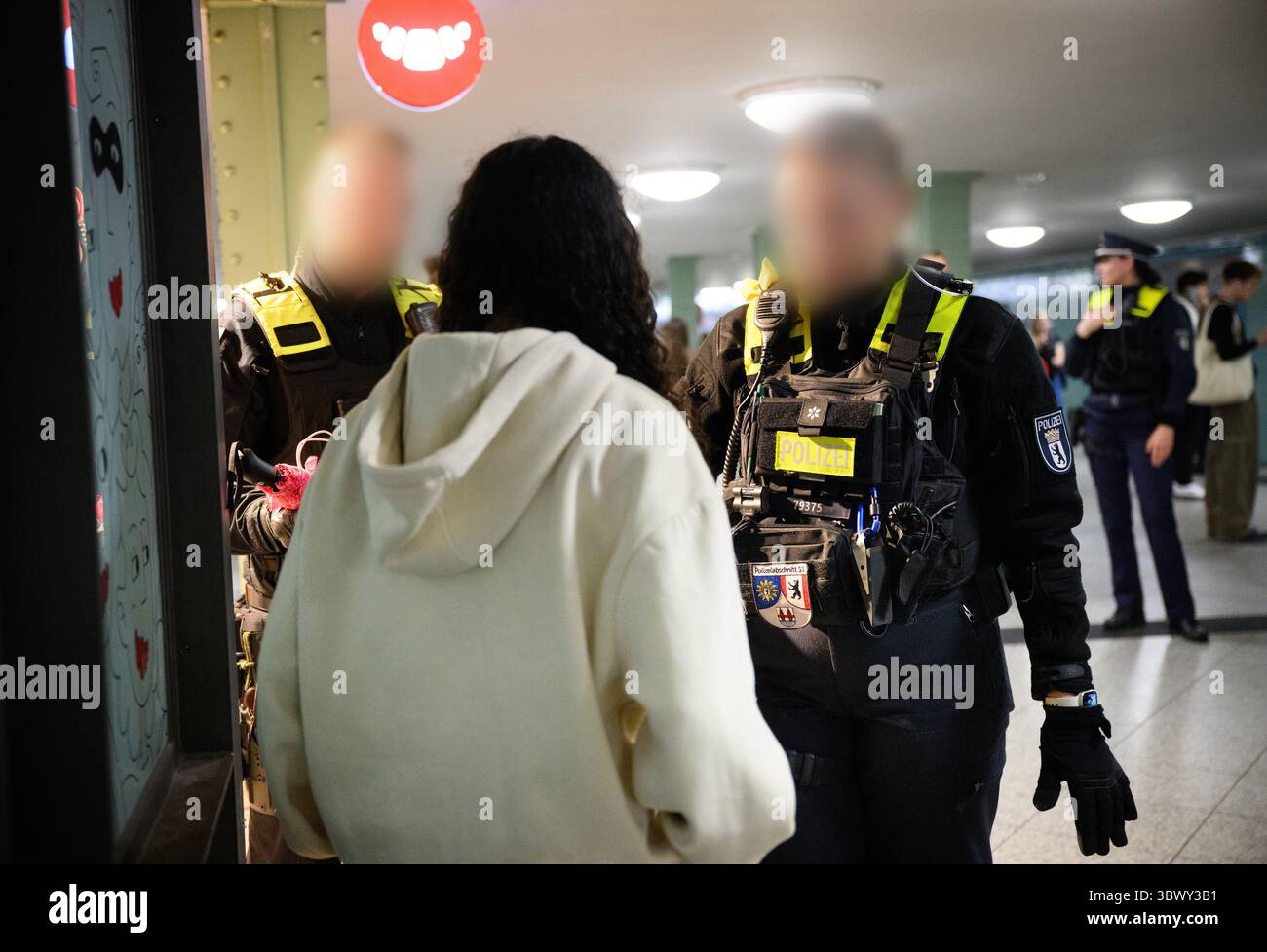 17 July 2025, Berlin: Police officers talk to a young woman at ...