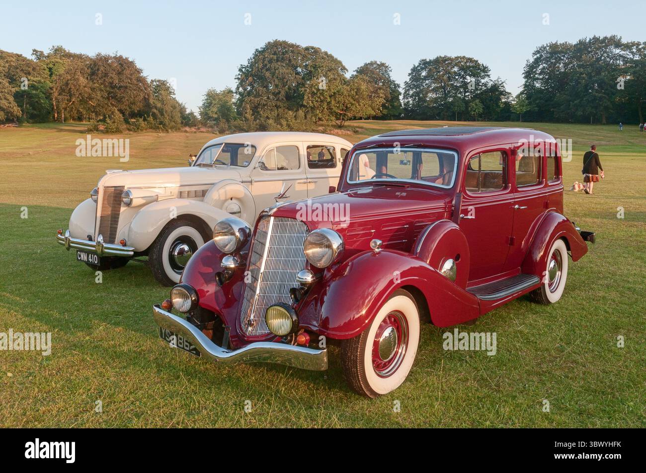 A red Hudson car parked next to a cream Buick at a classic vehicle show ...