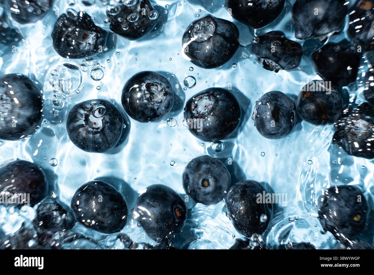 Berry background of fresh whole blueberries in water, splash of water ...