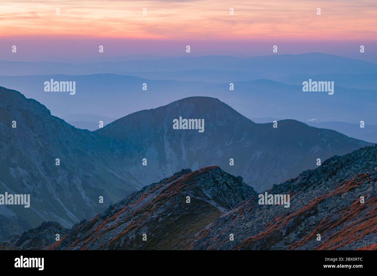 Aerial view of the dramatic, layered mountain ranges painted in hues of ...