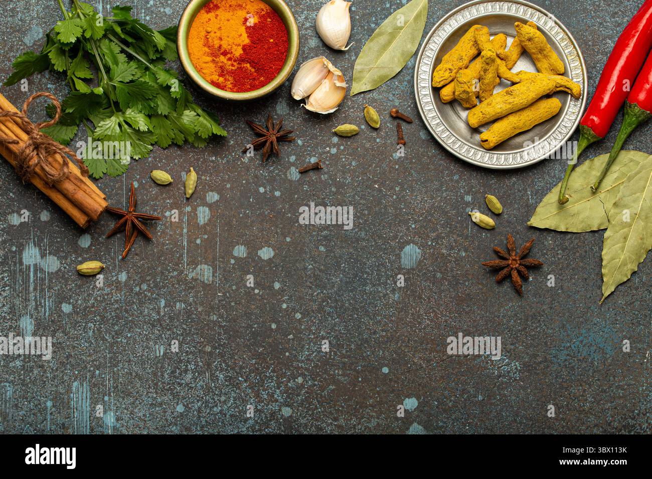 Aromatic Indian spices creating a frame on a dark textured background ...