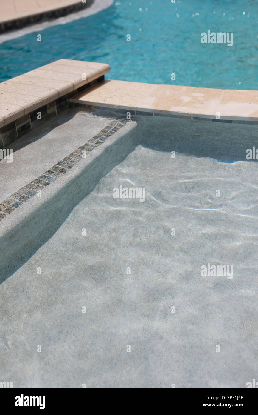 A tranquil pool area features clear water and is surrounded by well ...
