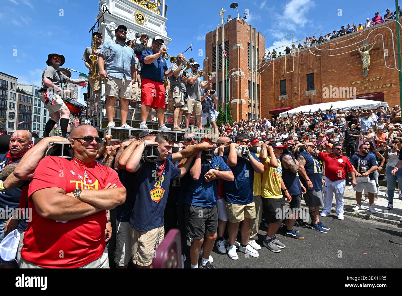 Lifters carry a 80-foot tall, 4-ton Giglio tower near the Shrine Church ...