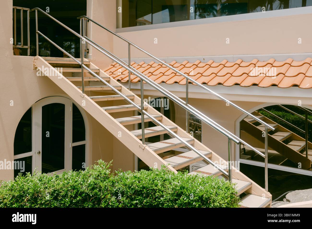 Stainless steel-railed staircase leads to an upper level of a modern ...