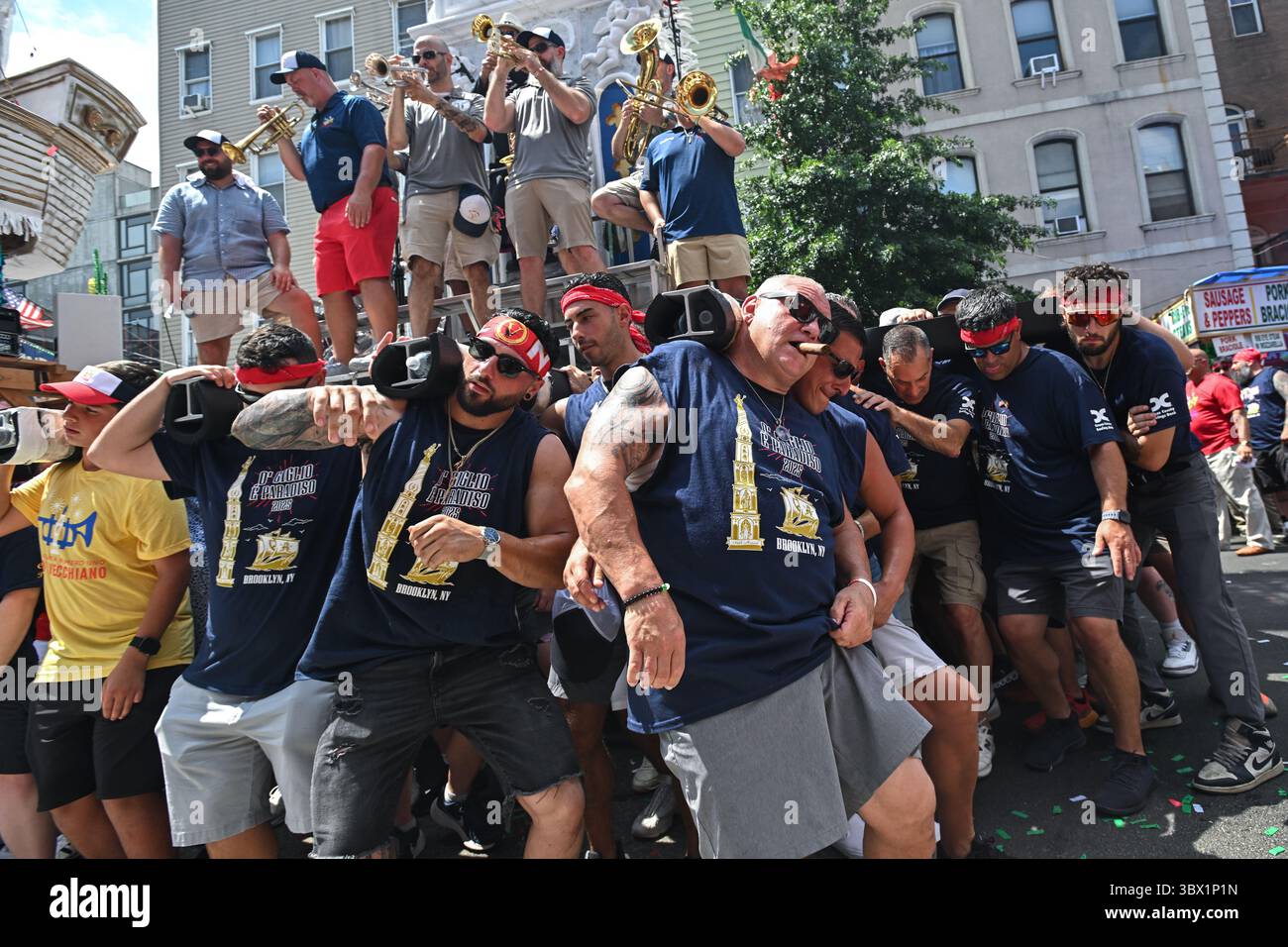 Lifters carry a 80-foot tall, 4-ton Giglio tower near the Shrine Church ...