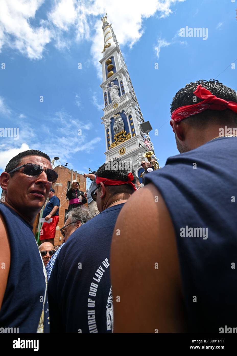 Lifters carry a 80-foot tall, 4-ton Giglio tower near the Shrine Church ...