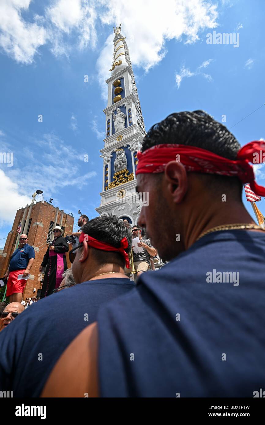 Lifters carry a 80-foot tall, 4-ton Giglio tower near the Shrine Church ...
