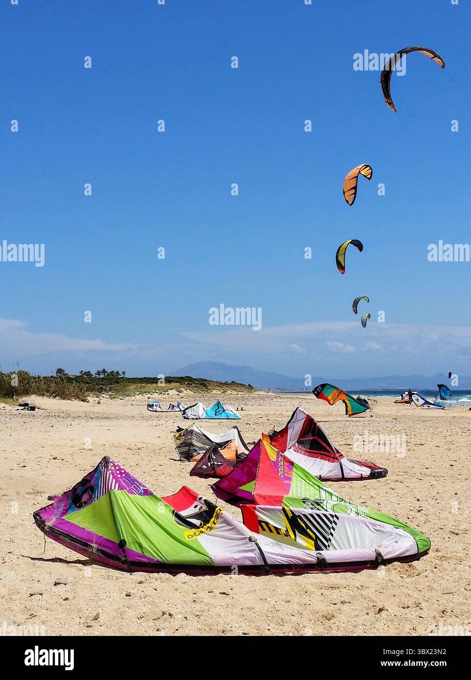 Colorful kitesurfing scene in Tarifa Spain with kites in the water and ...