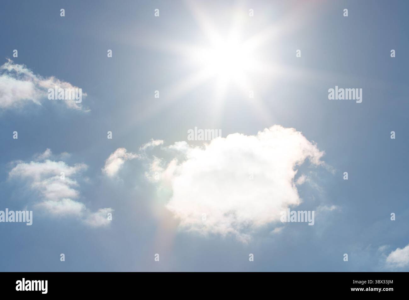Sun is radiating beams and lens flare rays across flat design sky with ...