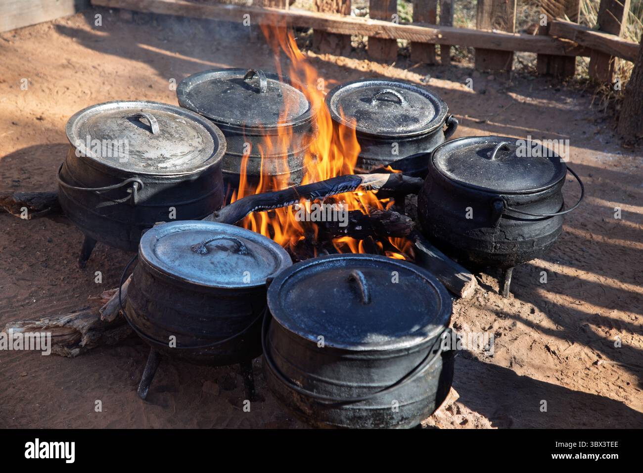 street food vendor african cooking setup a few 3 three legged pot ...