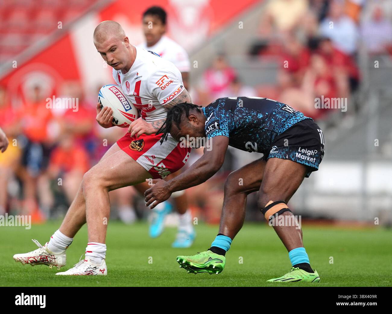 St Helens' George Delaney (left) is tackled by Leigh Leopards' Edwin ...