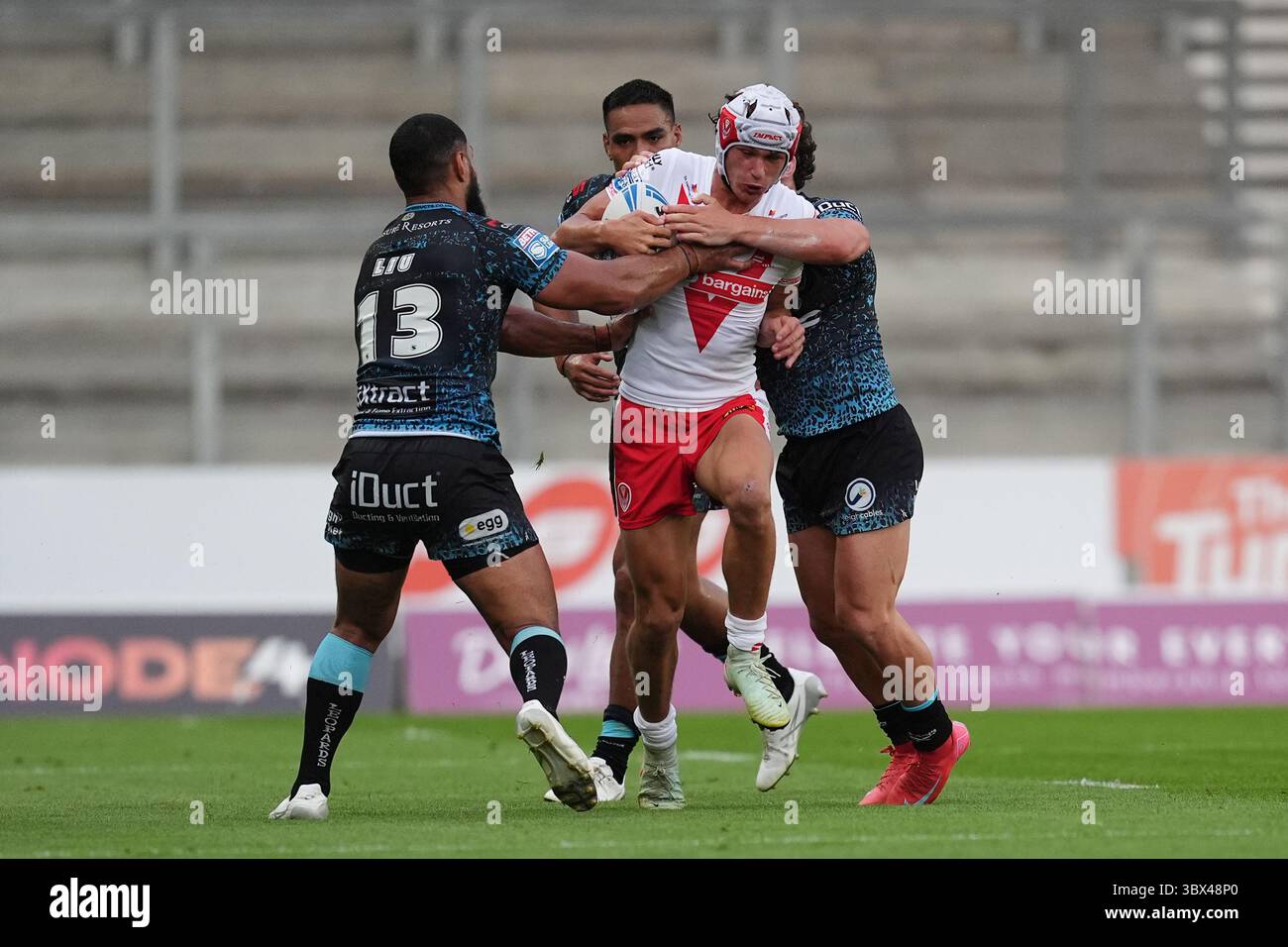 St Helens' Harry Robertson (centre) is tackled by Leigh Leopards' Isaac ...