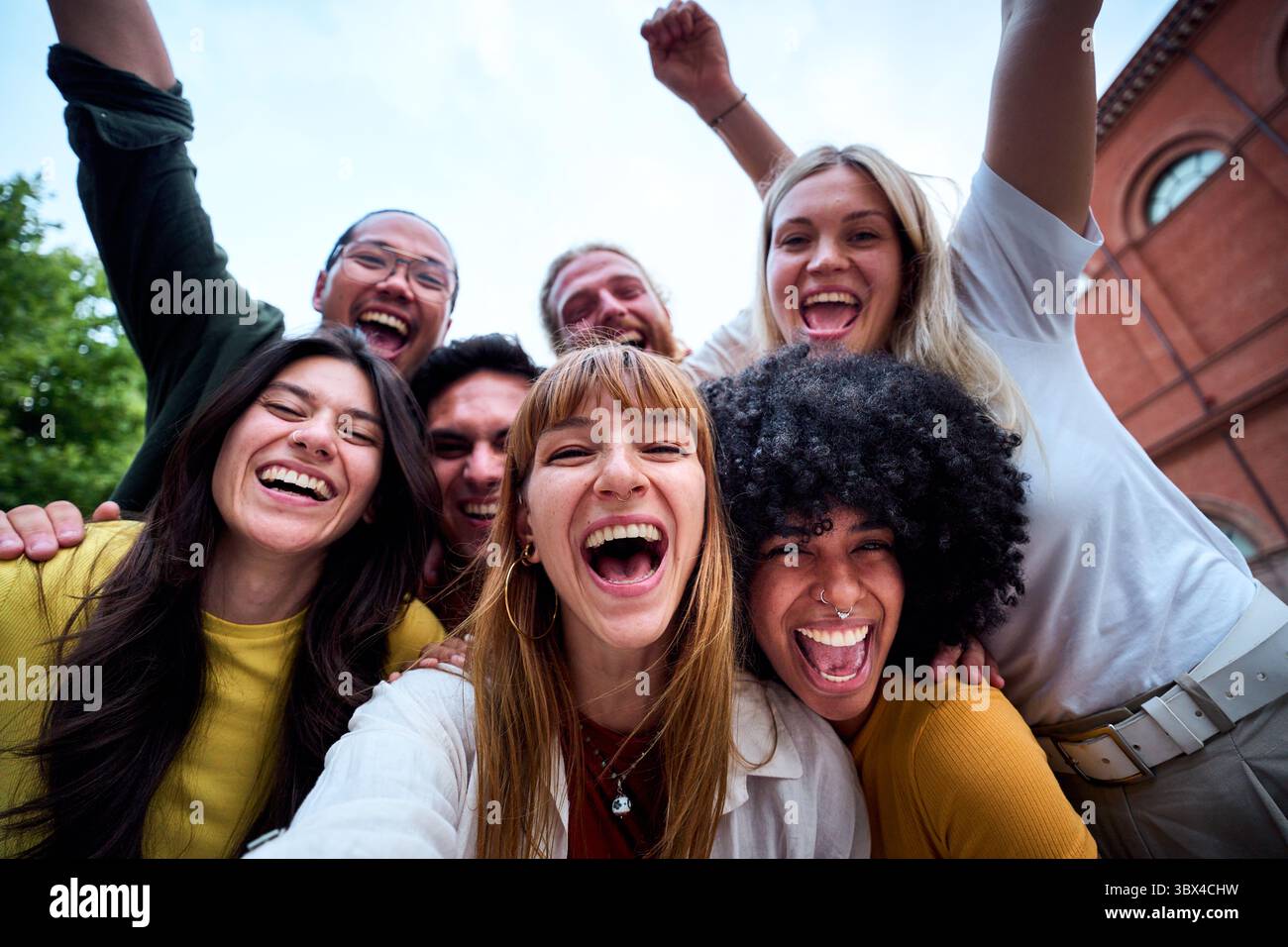 Happy young students celebrating success with arms raised and screaming ...