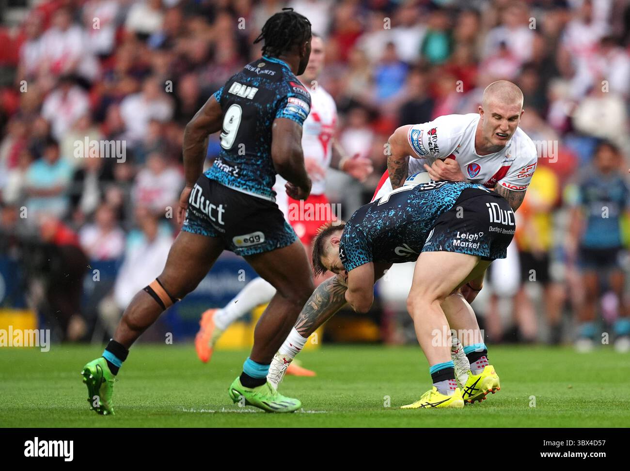 St Helens' George Delaney (right) is tackled by Leigh Leopards' Matt ...