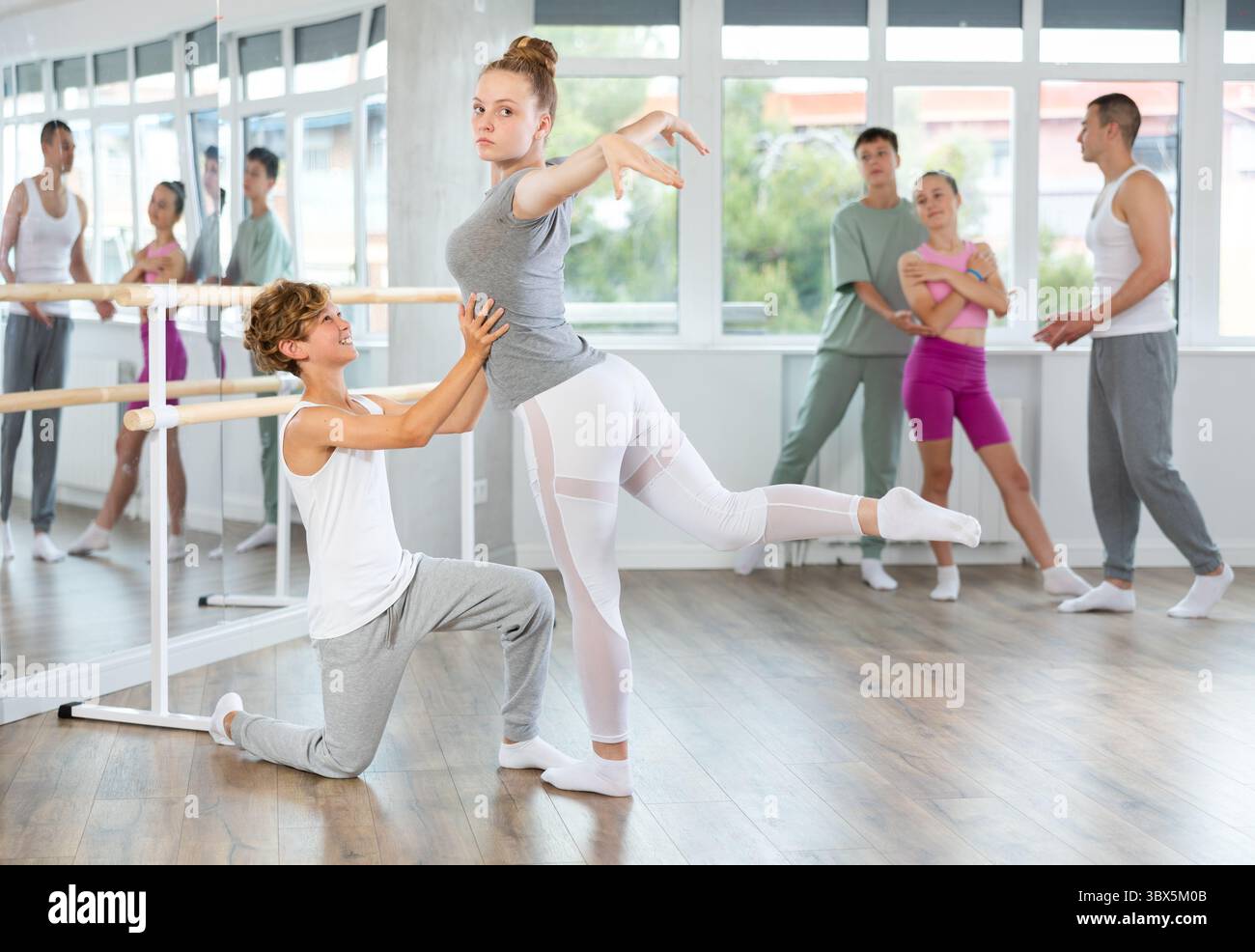 Ballet studio - teenagers girls and boys learn ballet movements in ...