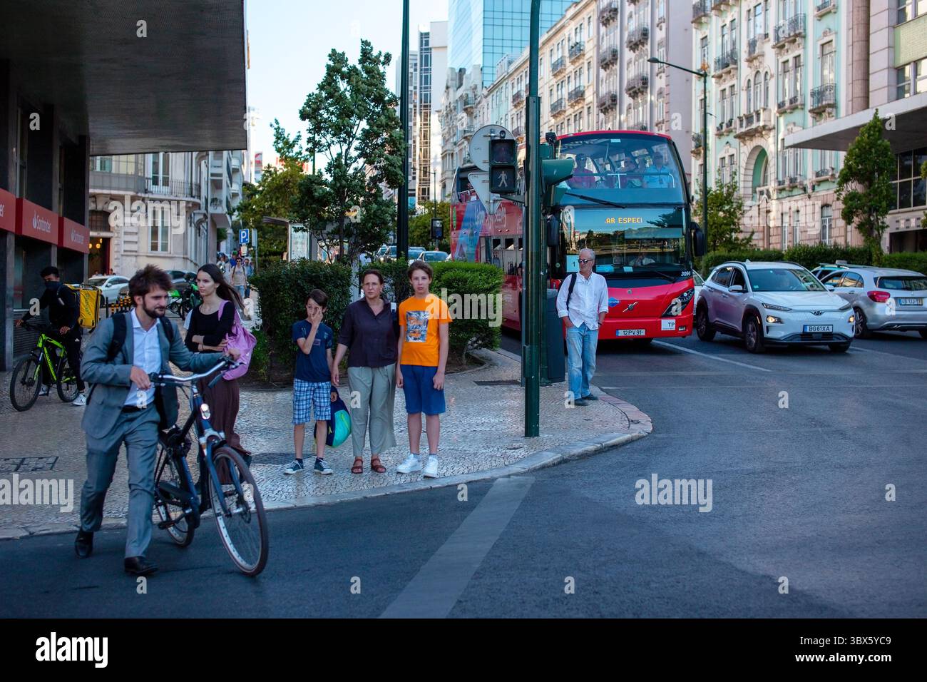 People waiting at a crosswalk next to a double-decker bus Stock Photo ...