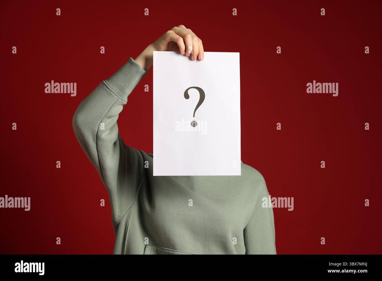 Anonymity. Woman hiding behind paper sheet with question mark on dark ...