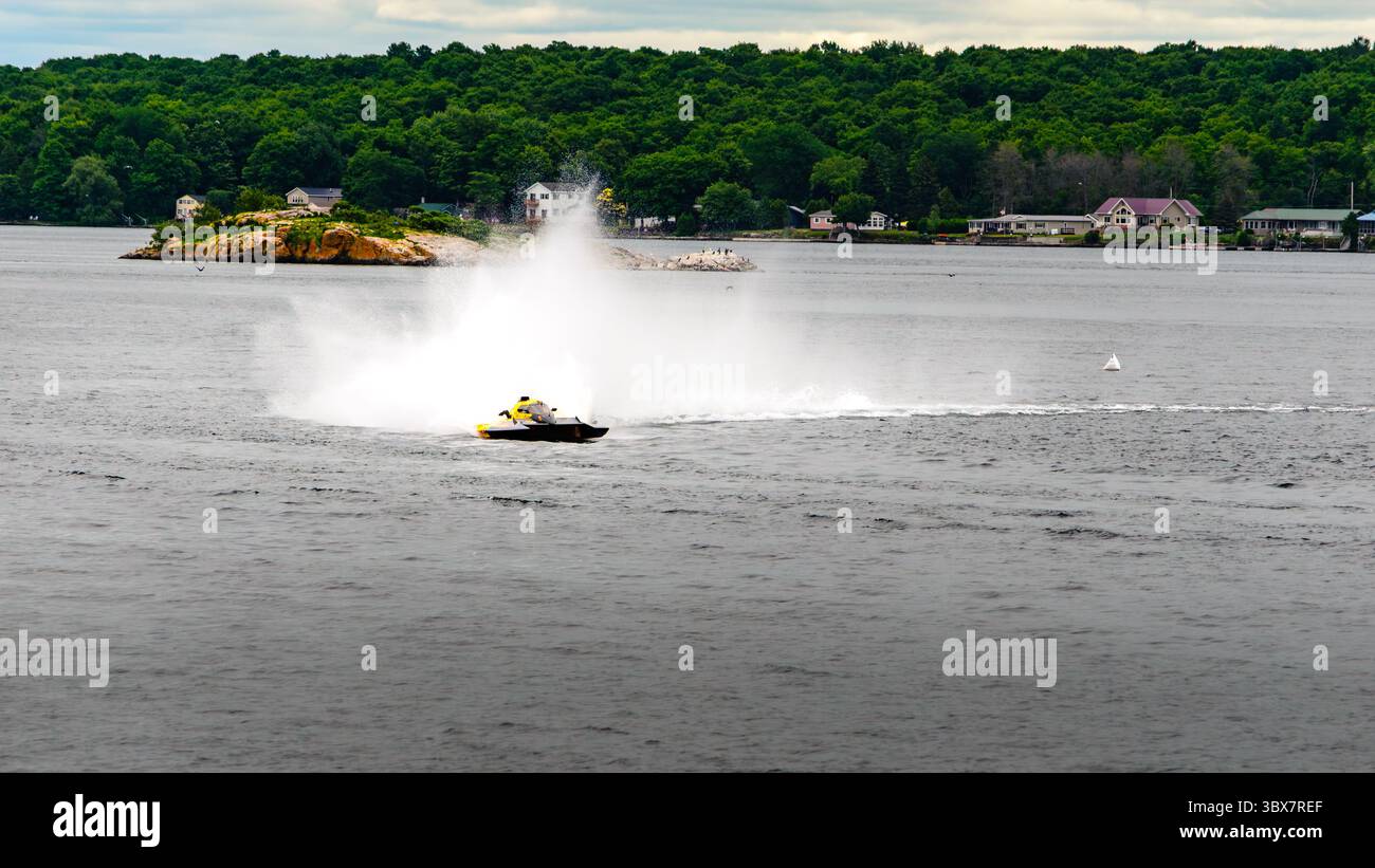 Single yellow and black hydroplane racing boat making a turn, throwing ...