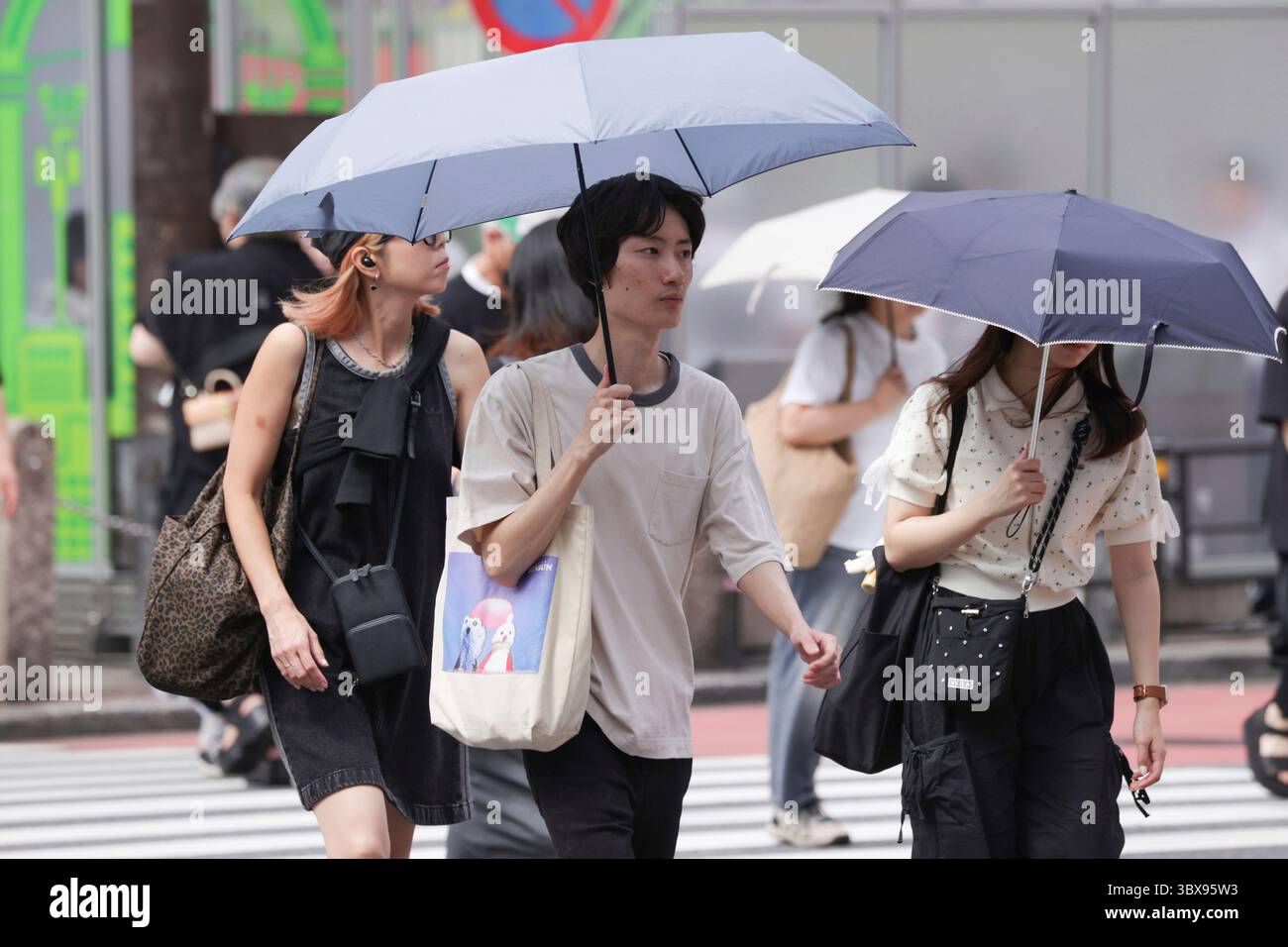 People walk under the strong sunlight in Tokyo, Japan, July 18, 2025 ...