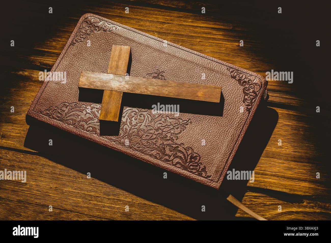 Wooden cross on bible at desk Stock Photo - Alamy