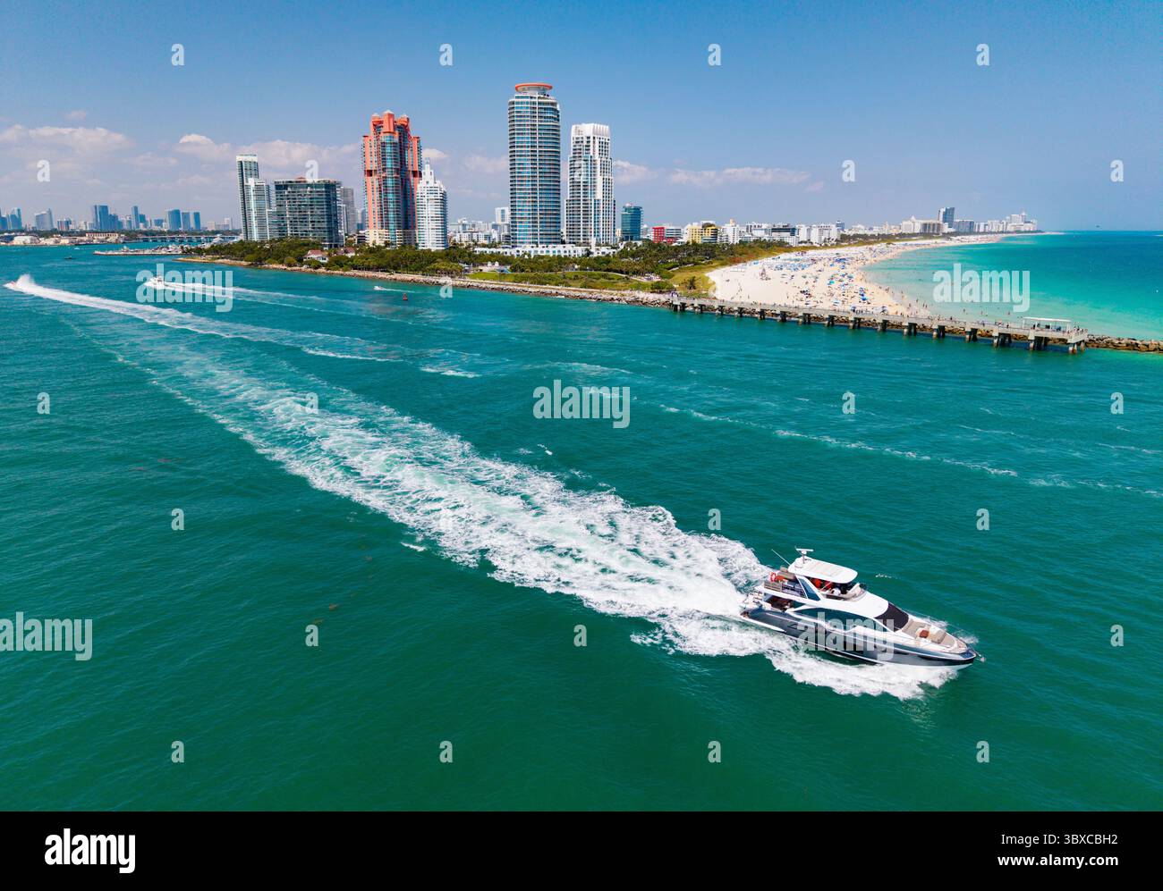 Luxury yacht cruising near Miami skyline. Aerial view of boats on ...