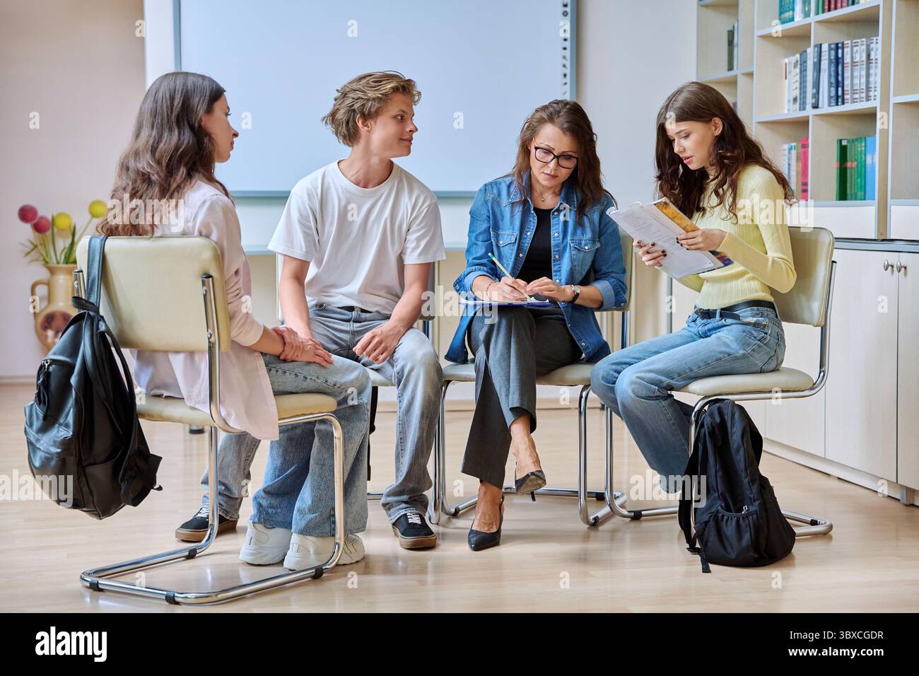 Group teamwork, students teenagers sitting in circle with female teacher, counselor Stock Photo ...