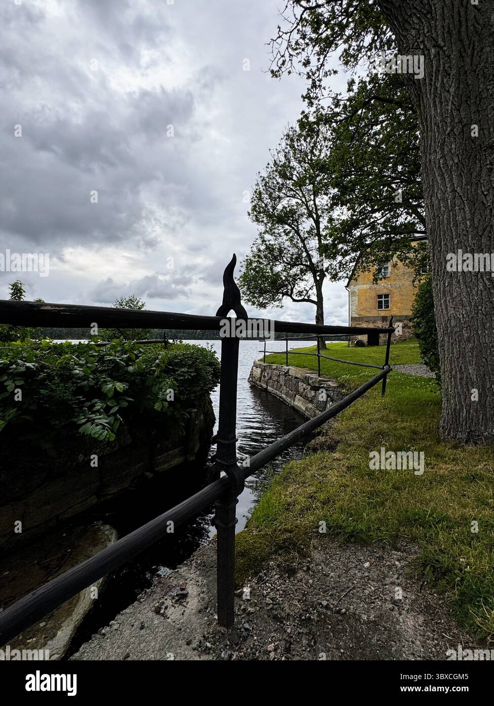 Canal and wrought iron fence near yellow manor house, Fagervik, Inkoo ...