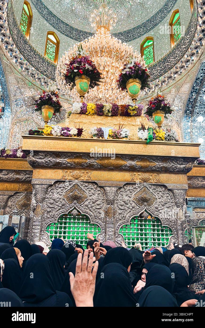Crowds in black gather around a beautifully adorned shrine in Karbala ...