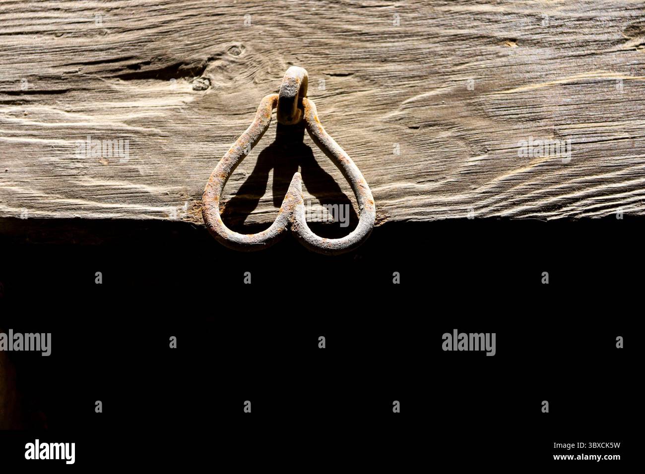 Inverted heart-shaped shackle on wooden beam Stock Photo - Alamy