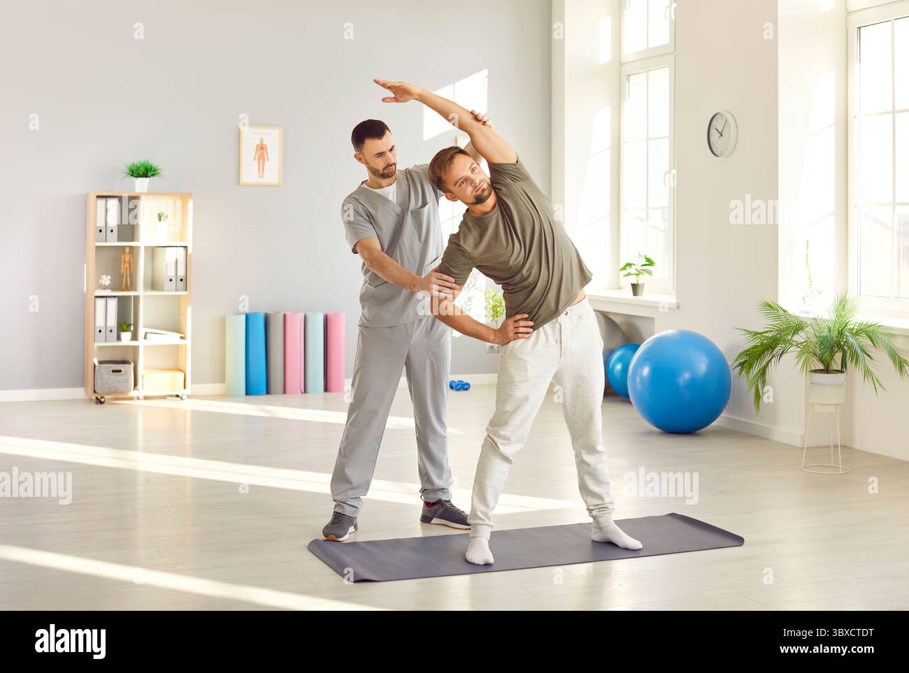 Therapist Assisting Patient With Stretching Exercises During ...