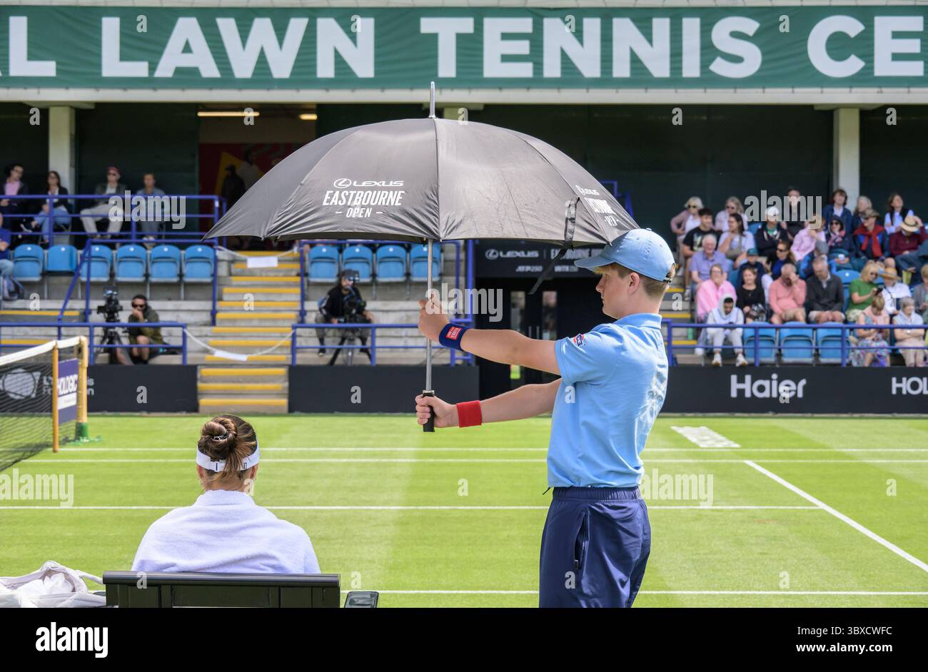 Lexus Eastbourne Open tennis 2025. Ball boy shading a player with an ...