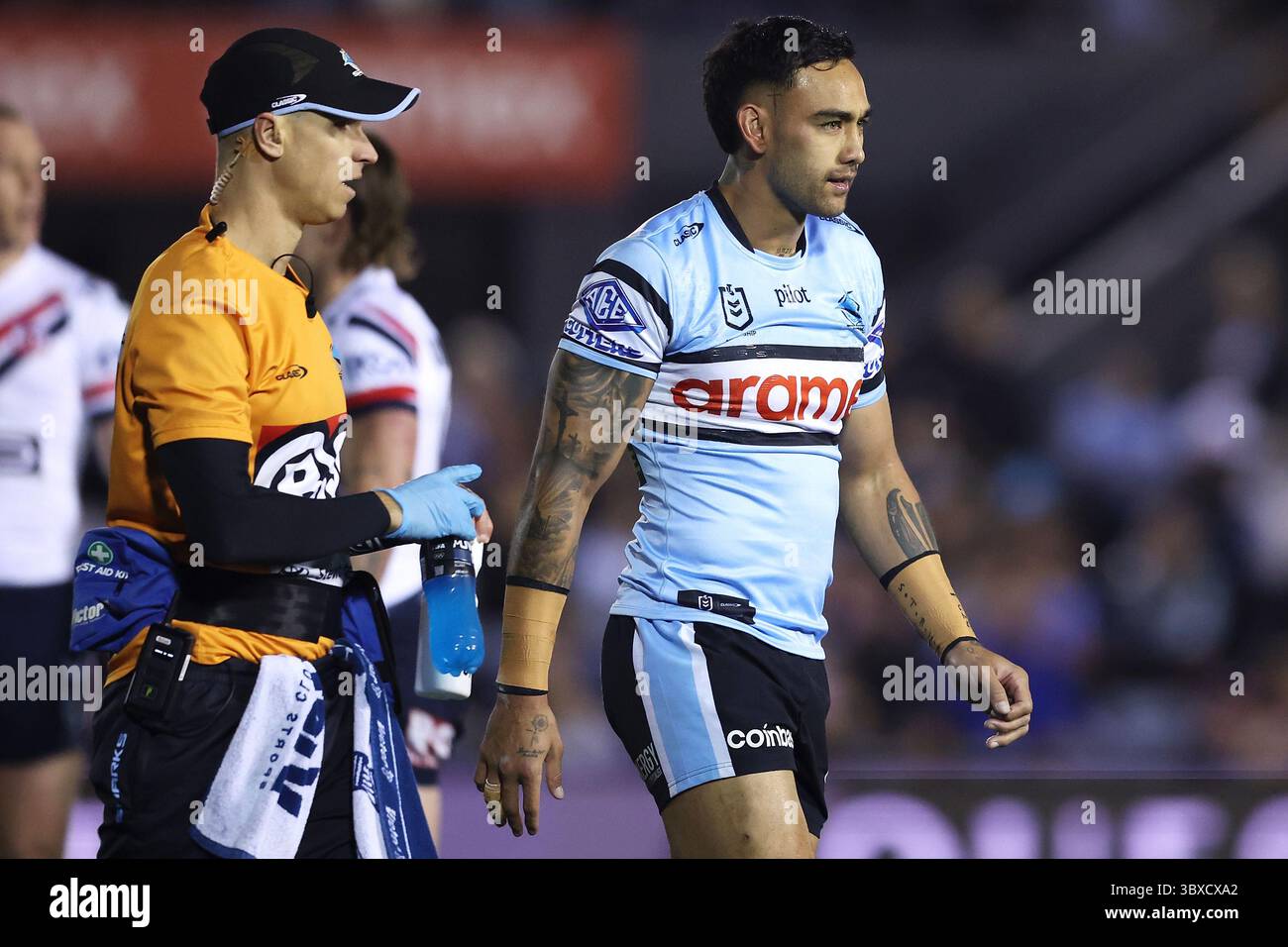 Briton Nikora of the Sharks leaves the field with the trainer for an ...