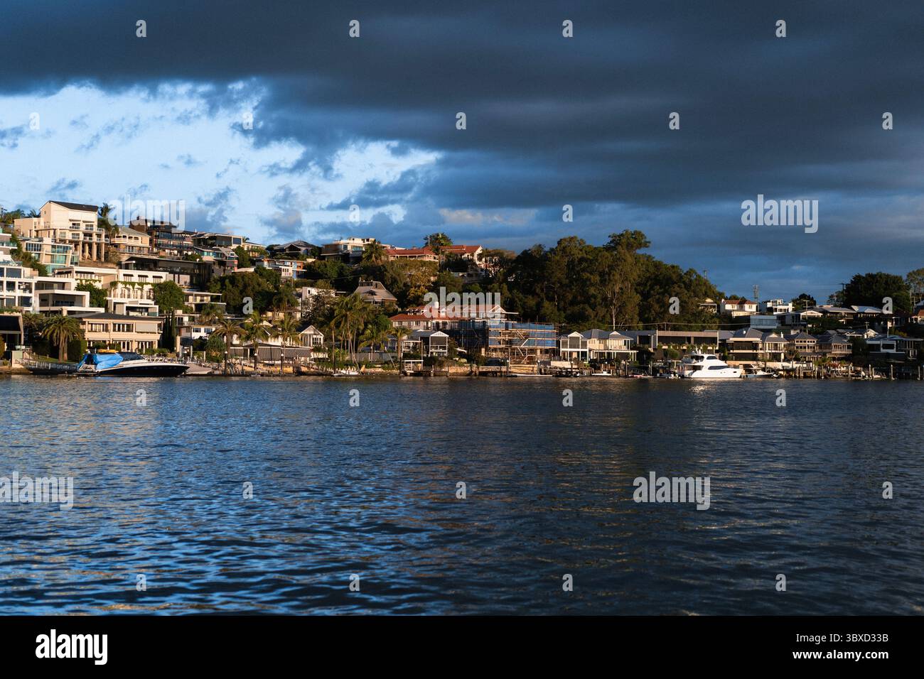 Riverside suburb under evening sky with scattered homes Stock Photo - Alamy
