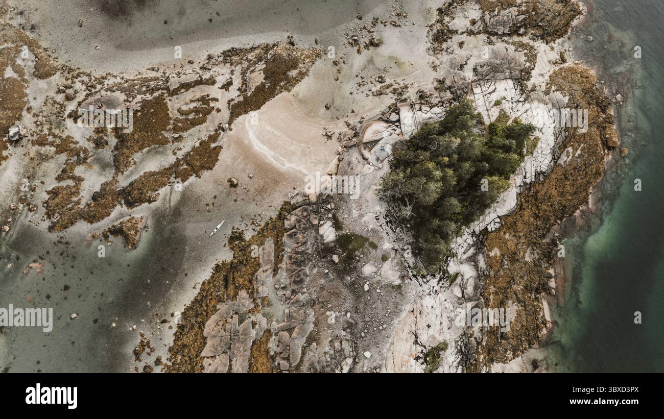 Aerial view of small island and tidal zone with sea kayak, Maine coast ...