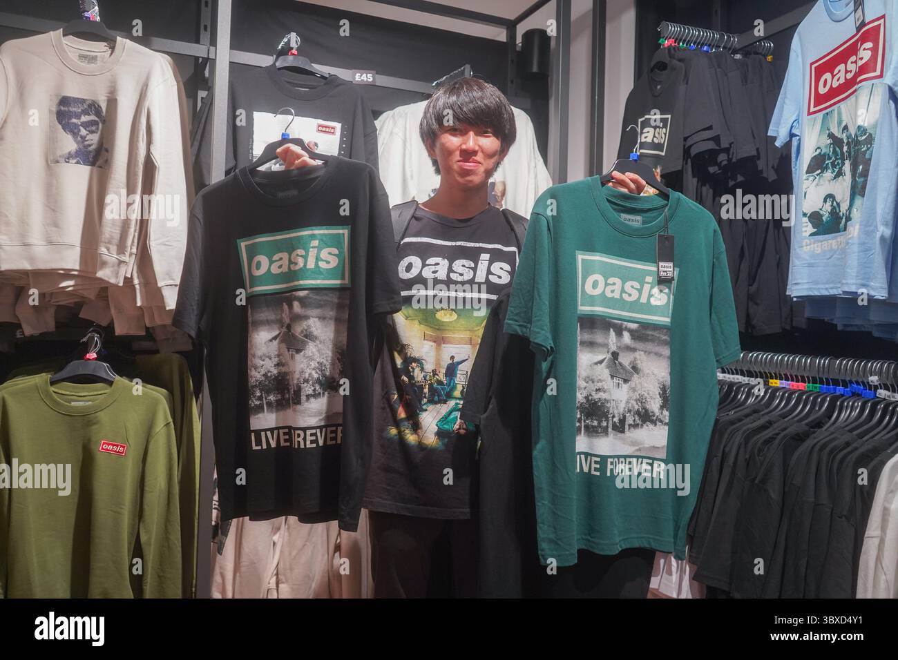London, UK. 18 July 2025 A customet with souvenir shirts at the Oasis ...