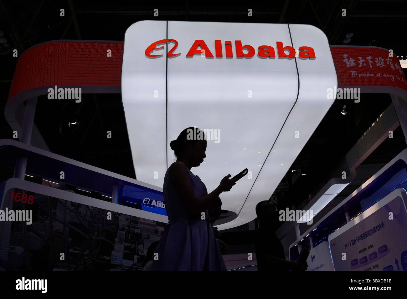 A visitor walks in front of Alibaba booth during the 3rd China ...