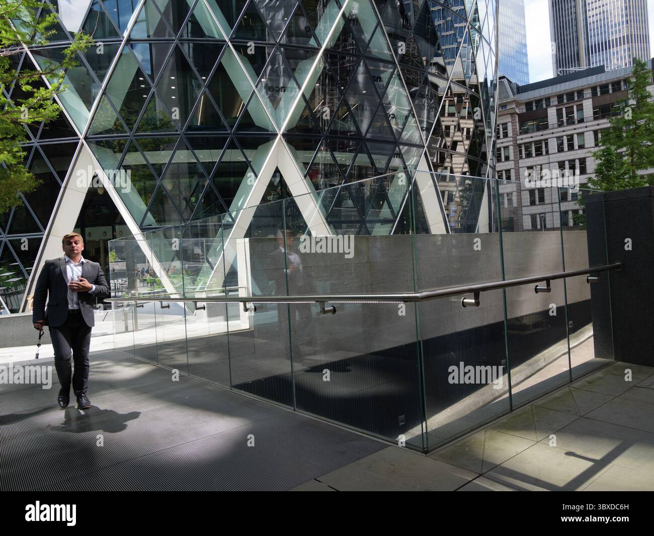 Pedestrians walk past the base of 30 St Mary Axe, widely known as The ...