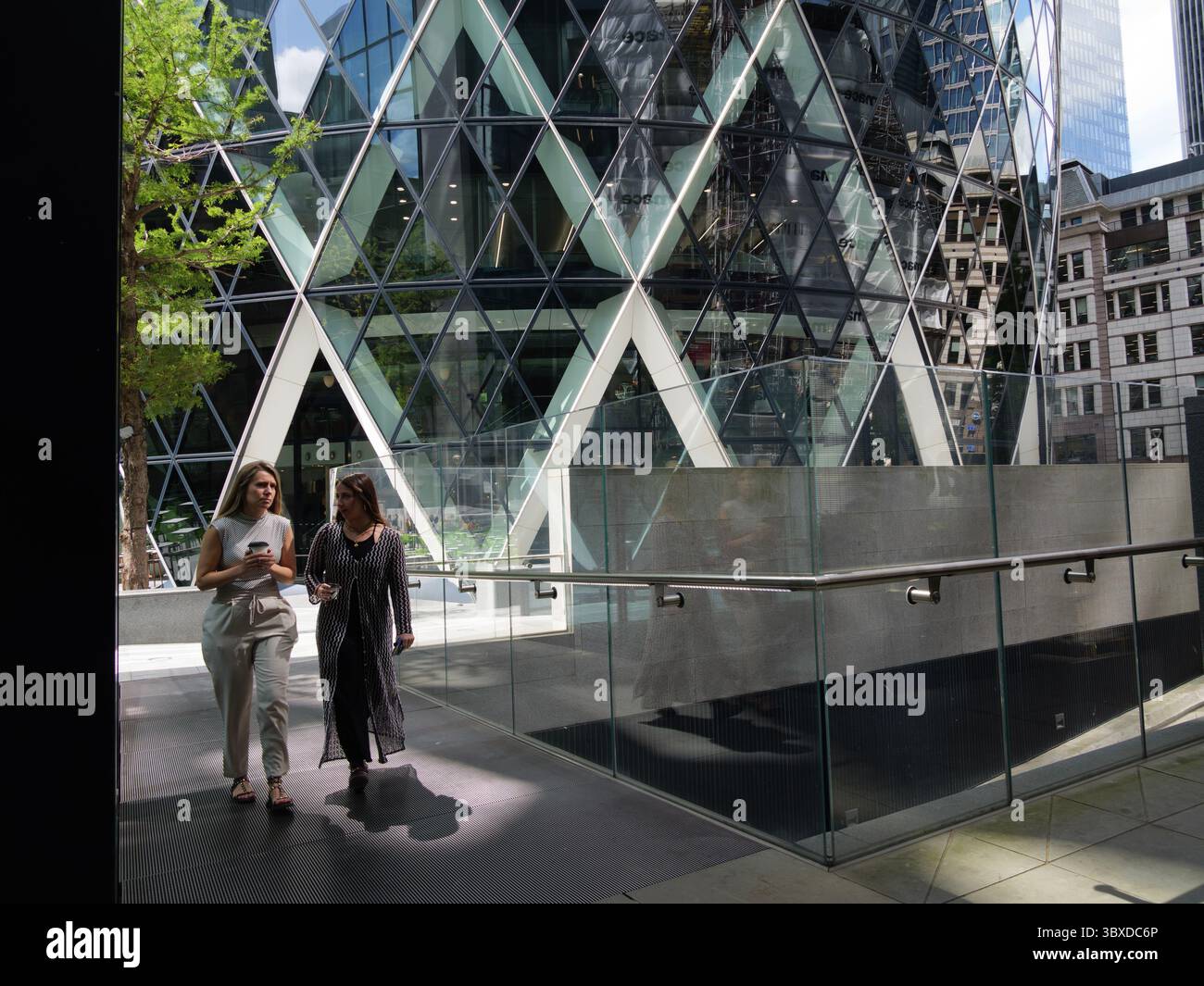 Pedestrians walk past the base of 30 St Mary Axe, widely known as The ...
