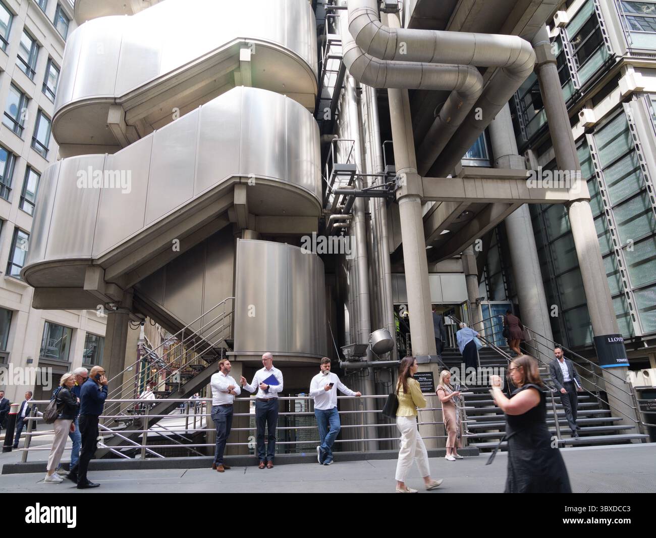White collar office workers take a break, leaning against the railings ...