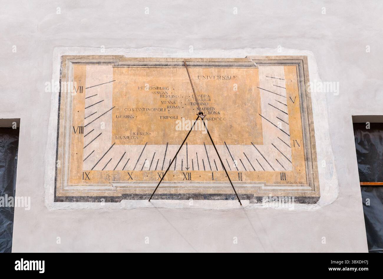 An old sundial on a stone wall, displaying Roman numerals and the names ...