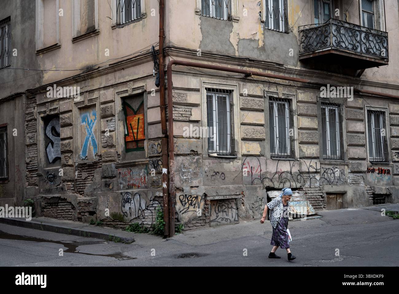 Tbilisi, Georgia. July 15th 2025. An elderly Georgian lady crossing the ...
