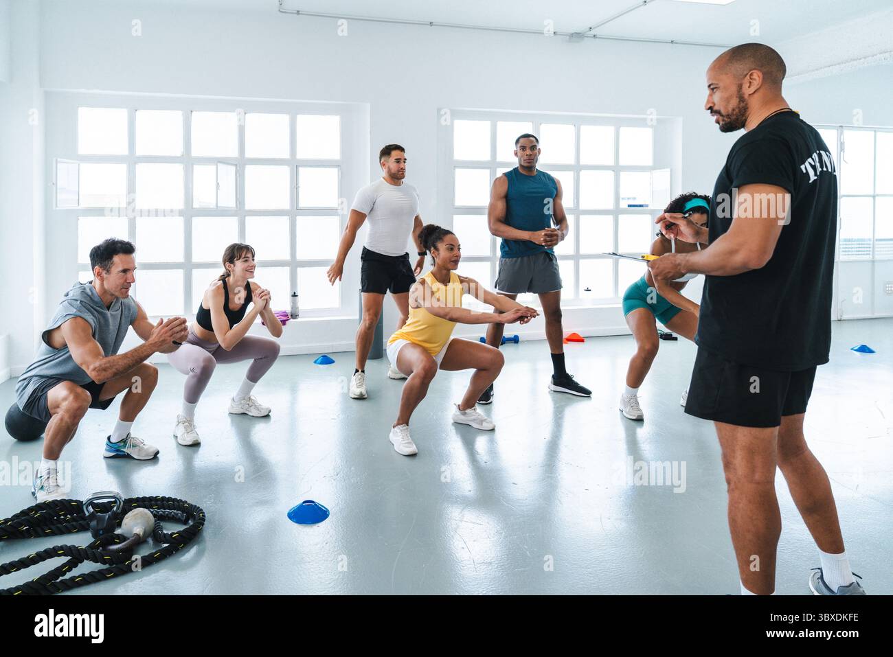 Multiethnic group of sportive people doing functional workout in ...