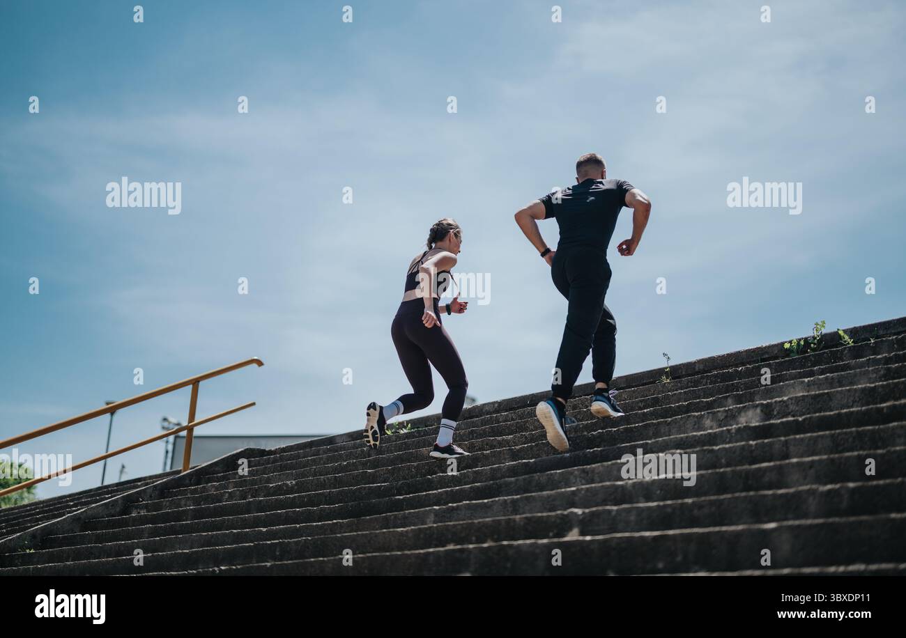 Two athletes running up stairs outdoors demonstrating determination and ...