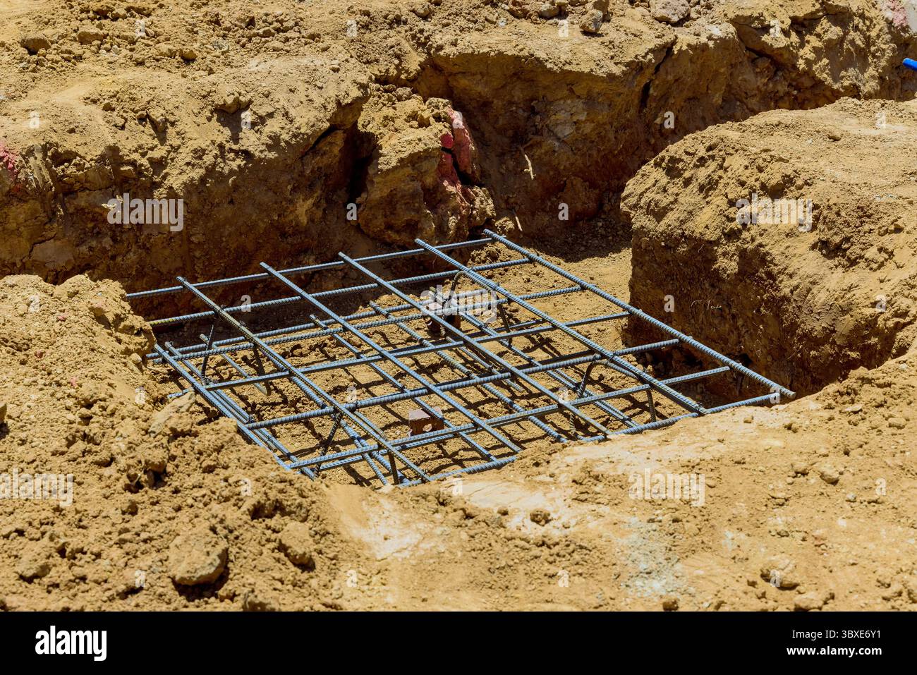 Workers prepare solid foundation by placing steel reinforcement bars in ...