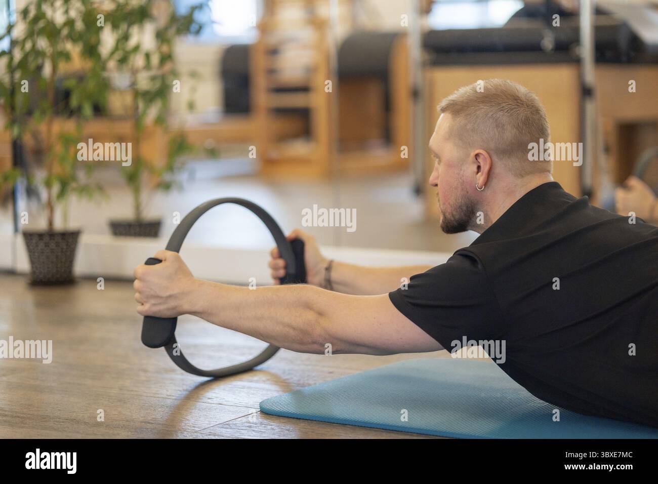 Male fitness Pilates trainer shows exercises on special simulators ...
