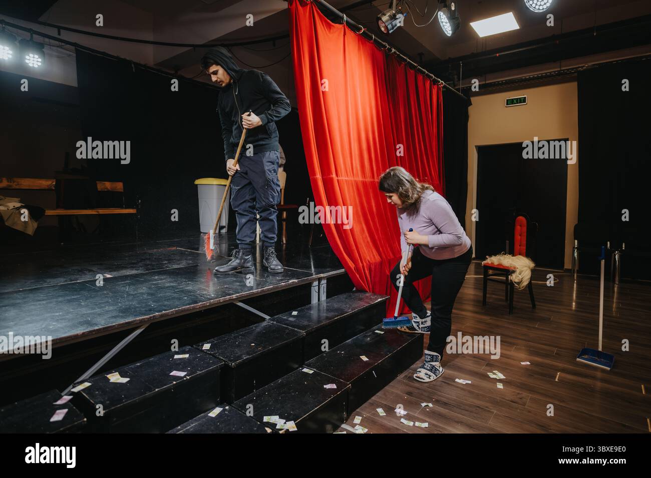 Actors cleaning the stage after a performance in a theatre setting ...