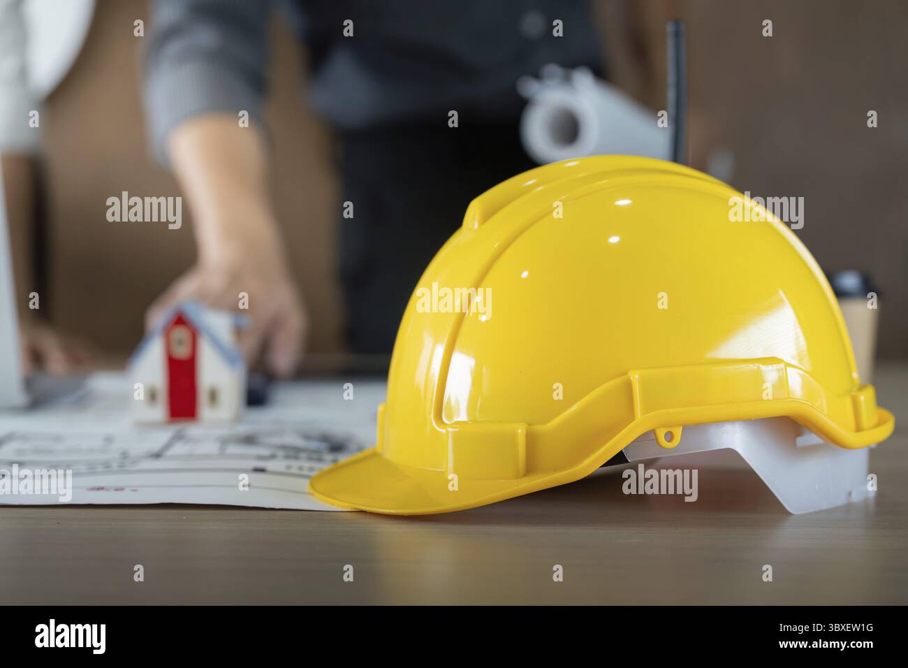 A construction engineer's hard hat is placed beside detailed blueprints ...