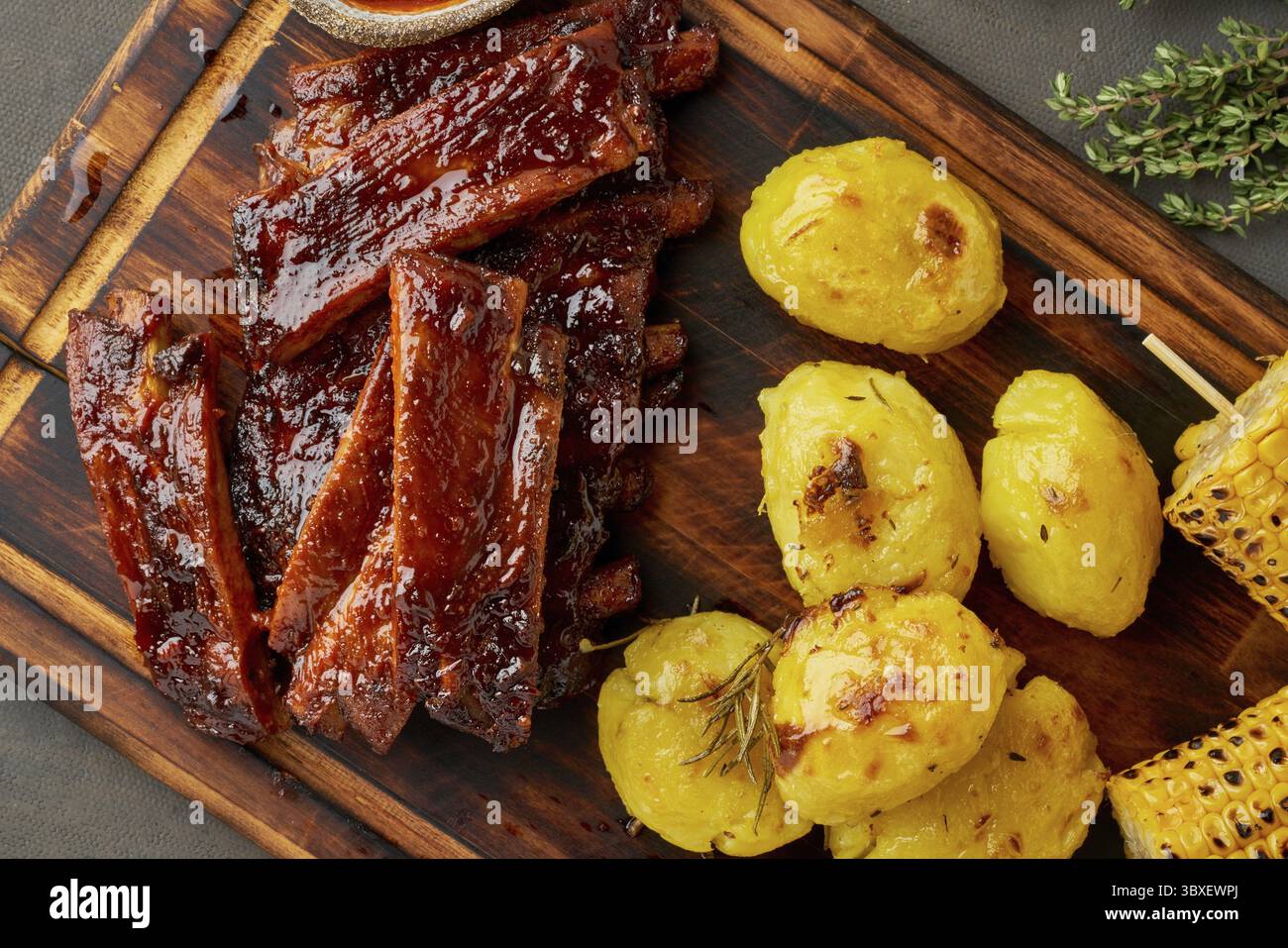 Spicy barbecue pork ribs, corn ears and crushed smashed potatoes. Slow ...